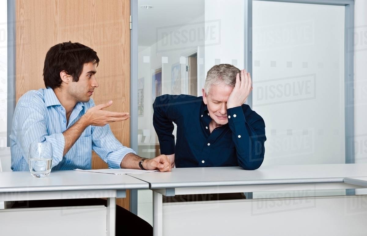 Man consoling work colleague - Stock Photo - Dissolve