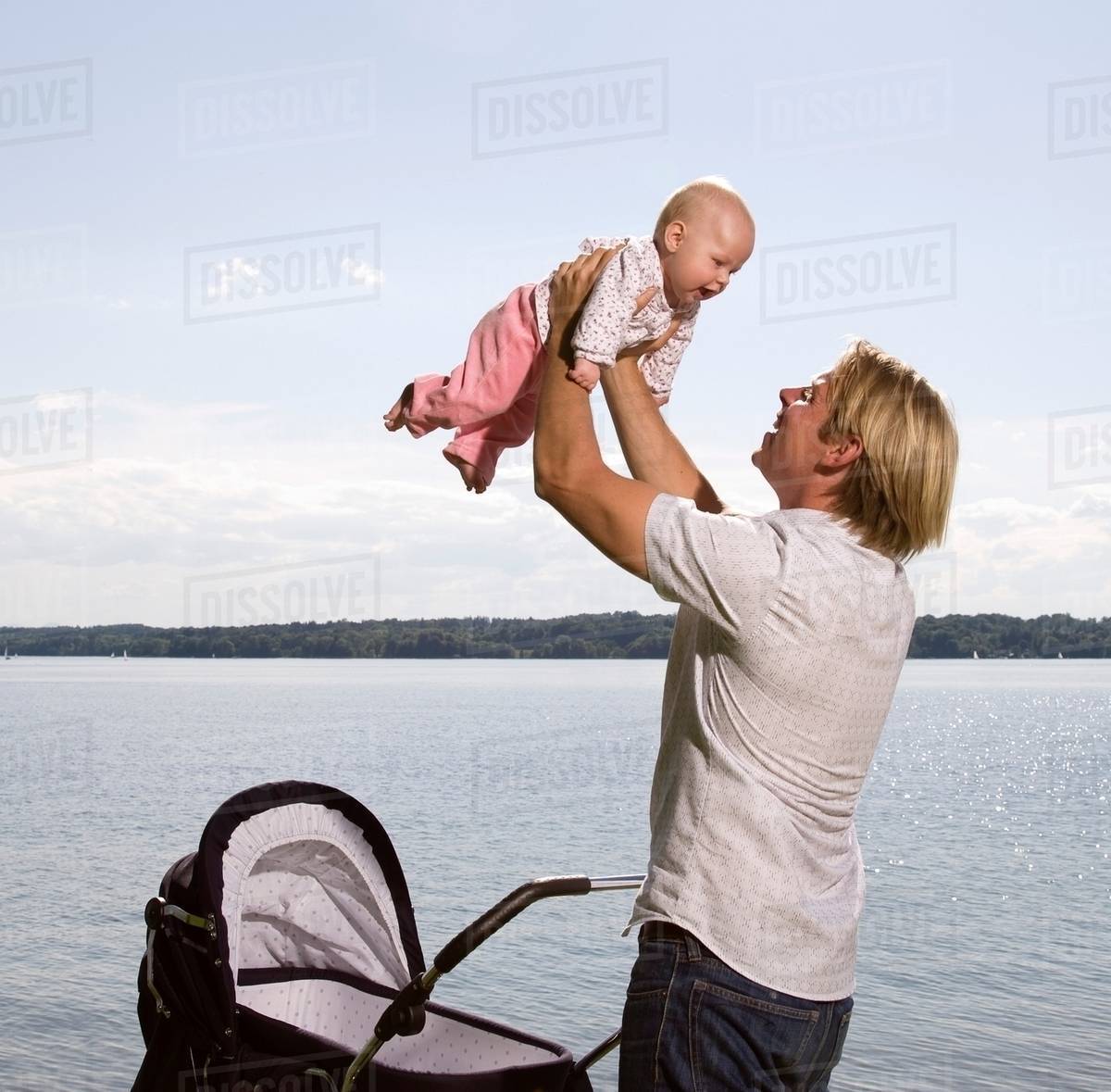 Dad lifting baby from pram - Stock Photo - Dissolve