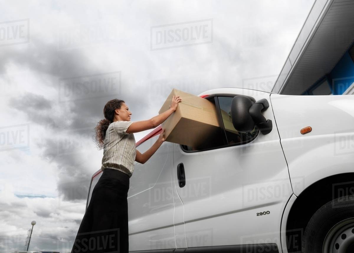 Woman with large box and delivery van - Stock Photo - Dissolve