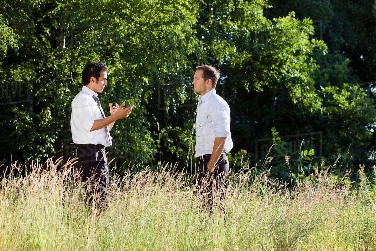Two businessmen talking in nature - Stock Photo - Dissolve