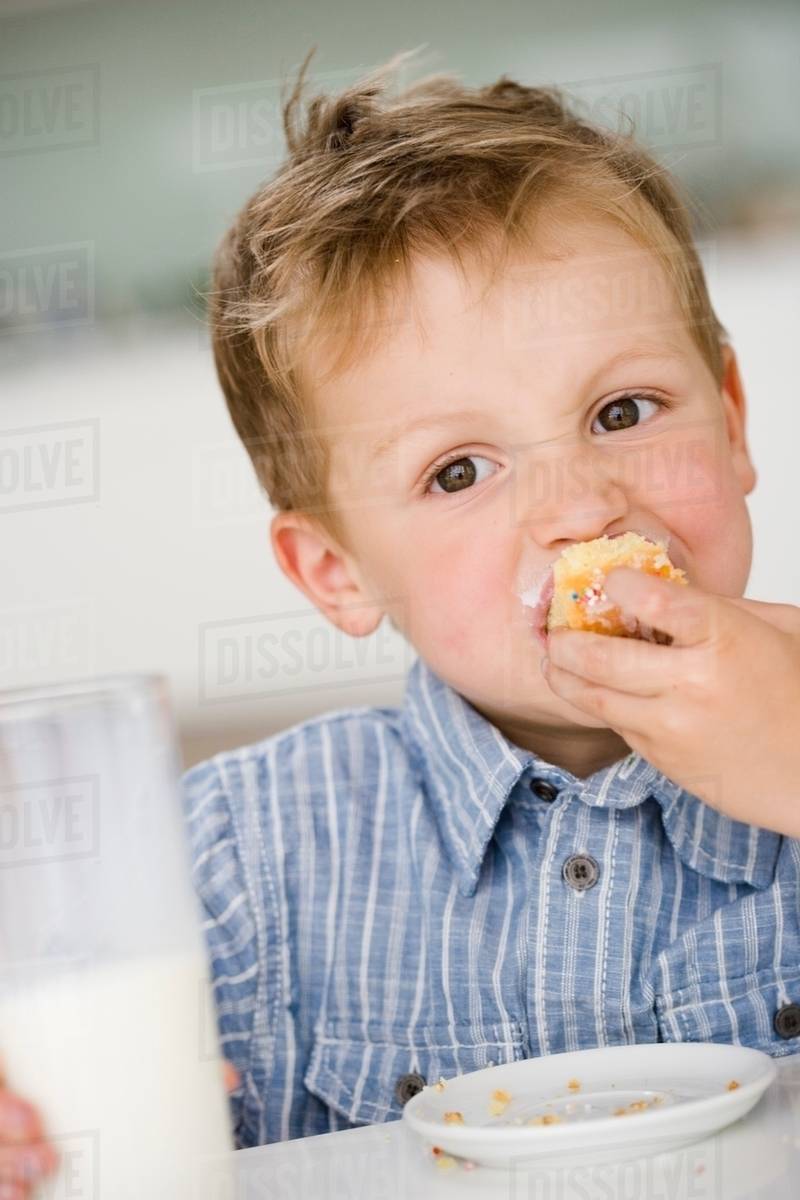 Young boy eating sweet dumpling - Stock Photo - Dissolve