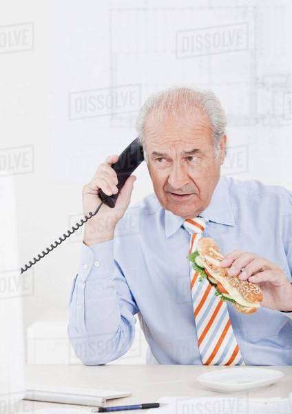 Man eating while on the phone - Royalty-free Stock Photo | Dissolve