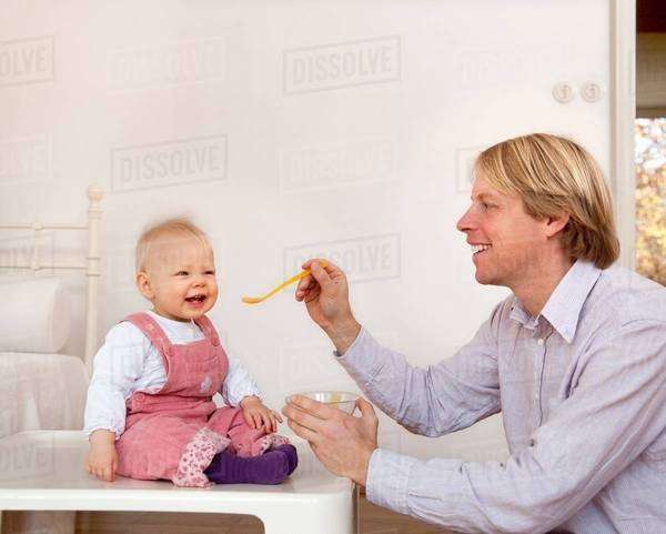 Father feeding baby - Stock Photo - Dissolve