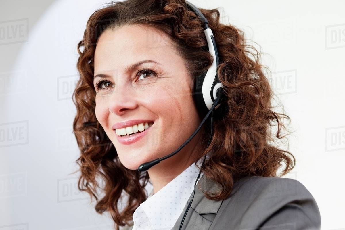 Female call center agent smiling - Stock Photo - Dissolve