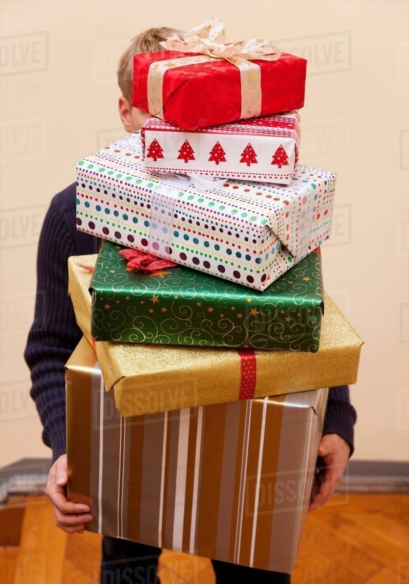 Man carrying pile of presents - Royalty-free Stock Photo | Dissolve