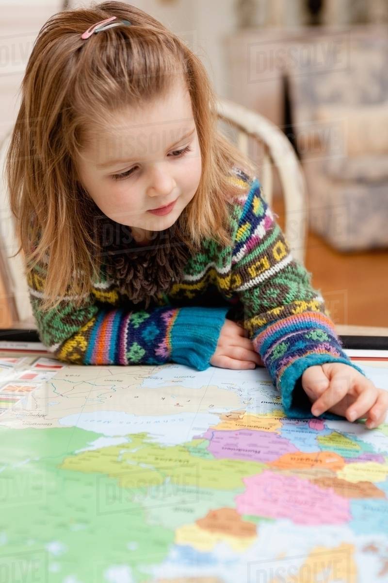Little girl exploring map with finger - Royalty-free Stock Photo | Dissolve