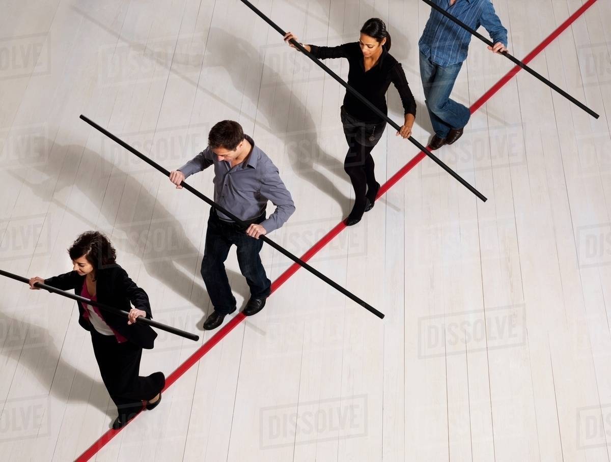 People balancing on thin red line - Stock Photo - Dissolve
