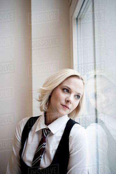 Businesswoman leaning against window - Royalty-free Stock Photo | Dissolve