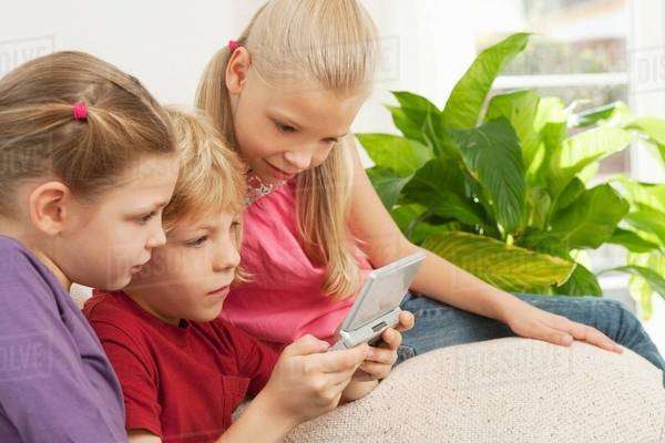 Children playing a game on a console - Stock Photo - Dissolve