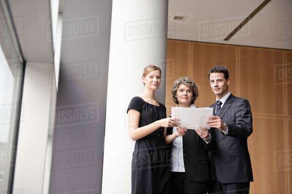 Business people looking at paperwork - Stock Photo - Dissolve