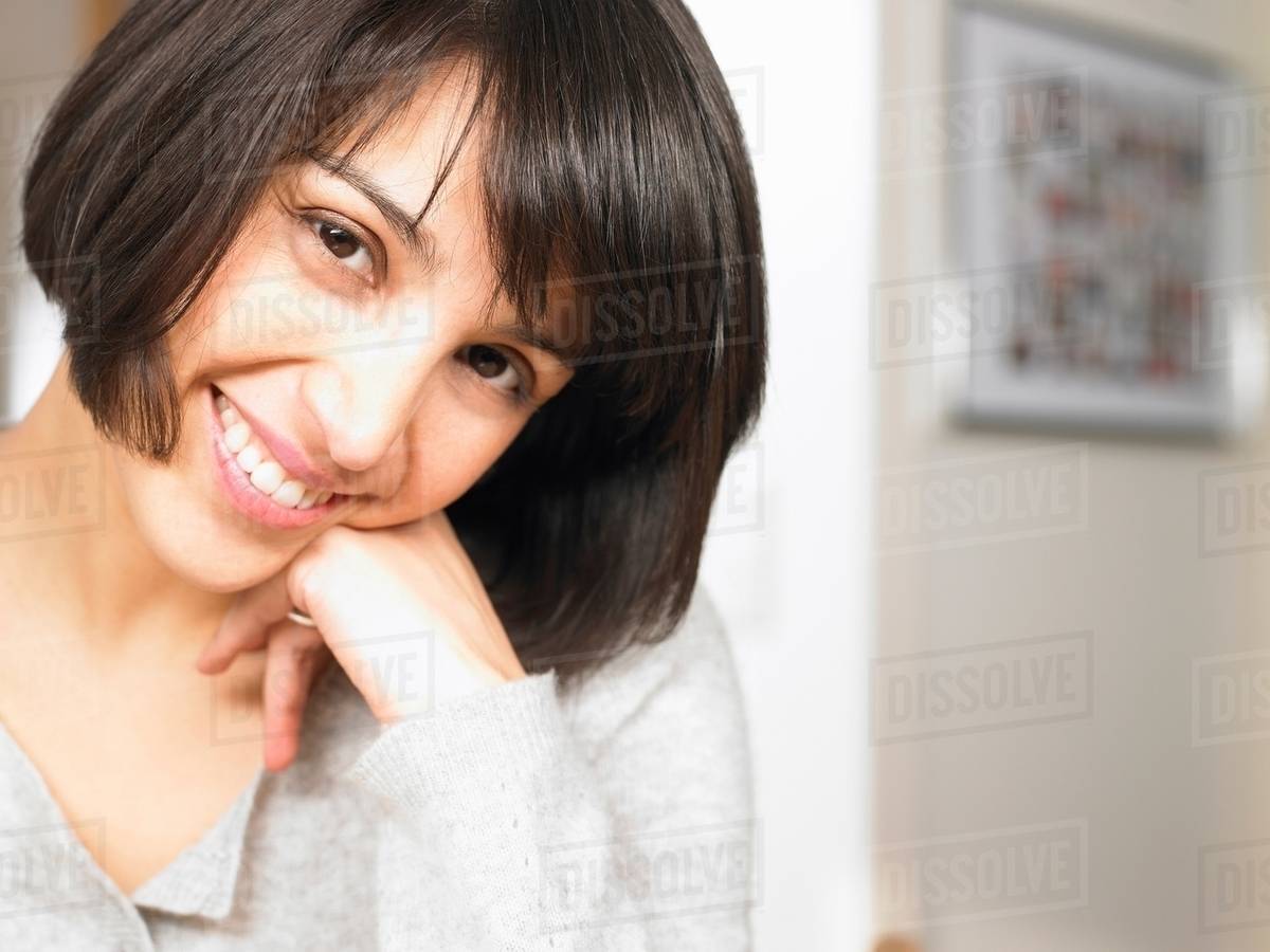 Woman looking at camera, smiling - Stock Photo - Dissolve