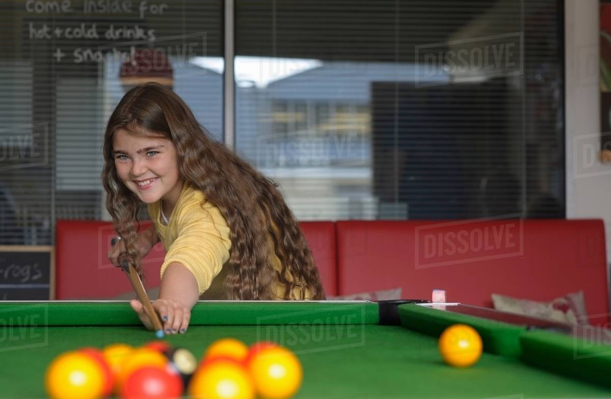 Young girl playing pool - Stock Photo - Dissolve