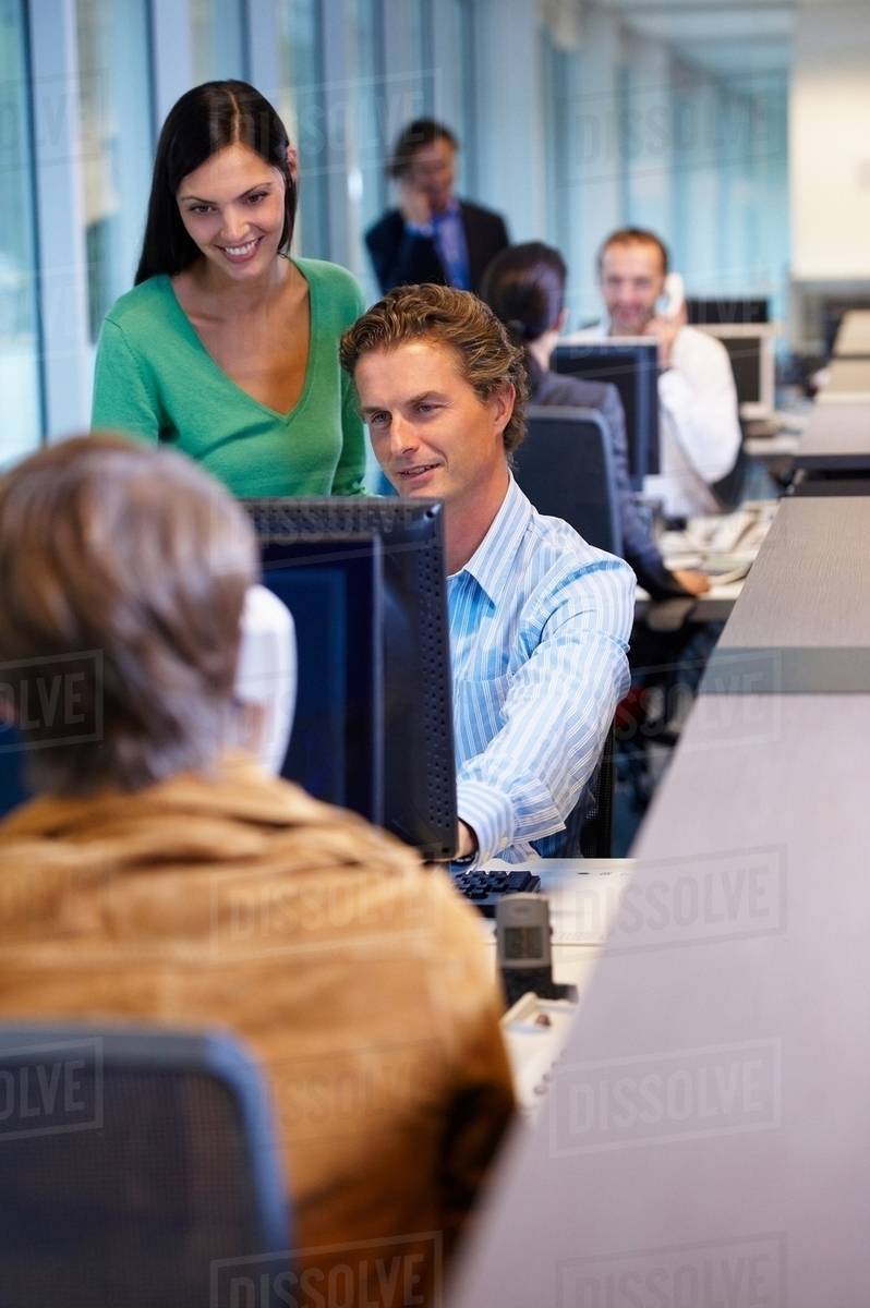 Office workers looking at a computer - Stock Photo - Dissolve