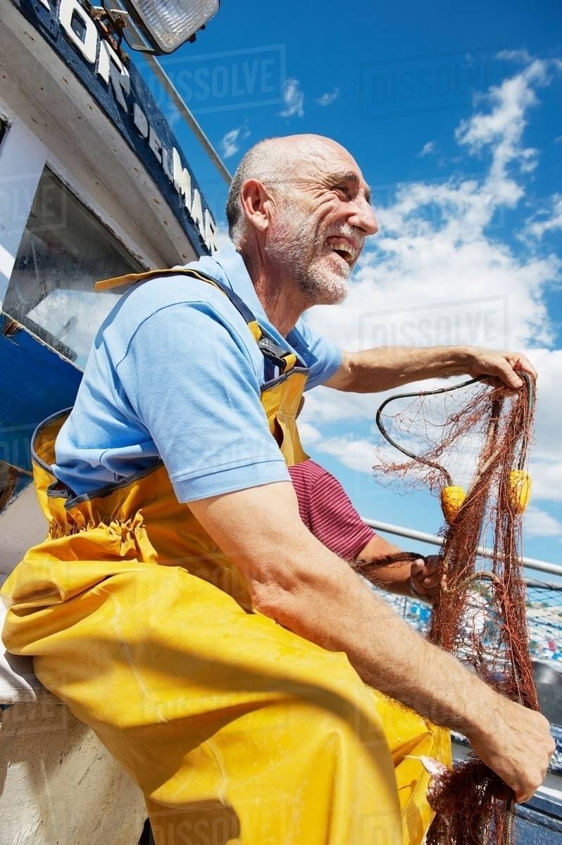 Fisherman holding fishing nets - Stock Photo - Dissolve