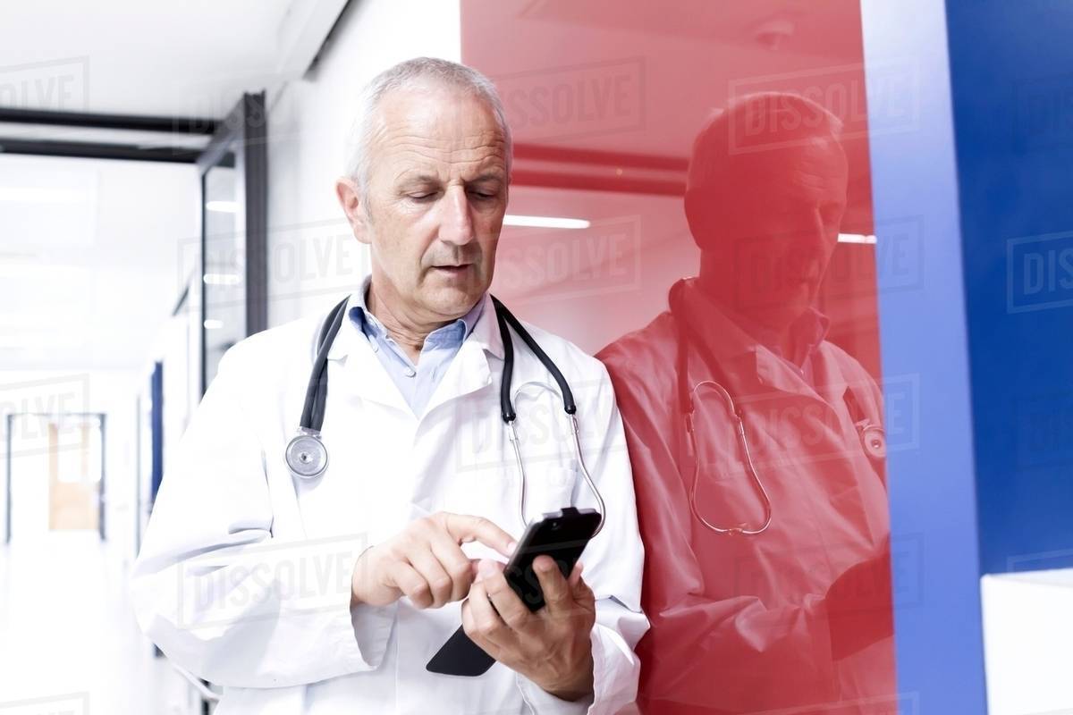 Male doctor using smartphone - Stock Photo - Dissolve