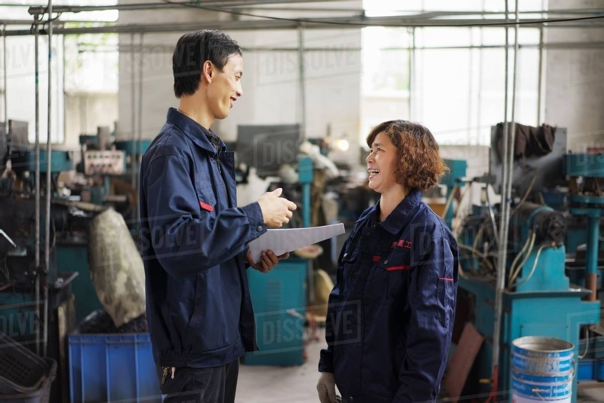 Supervisor explaining to worker in crane factory, Jiangsu Province ...