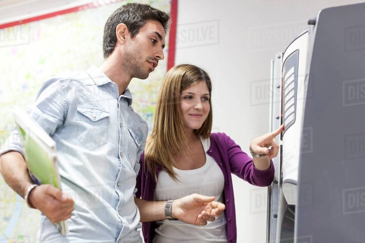 Young man and woman using vending machine - Royalty-free Stock Photo ...