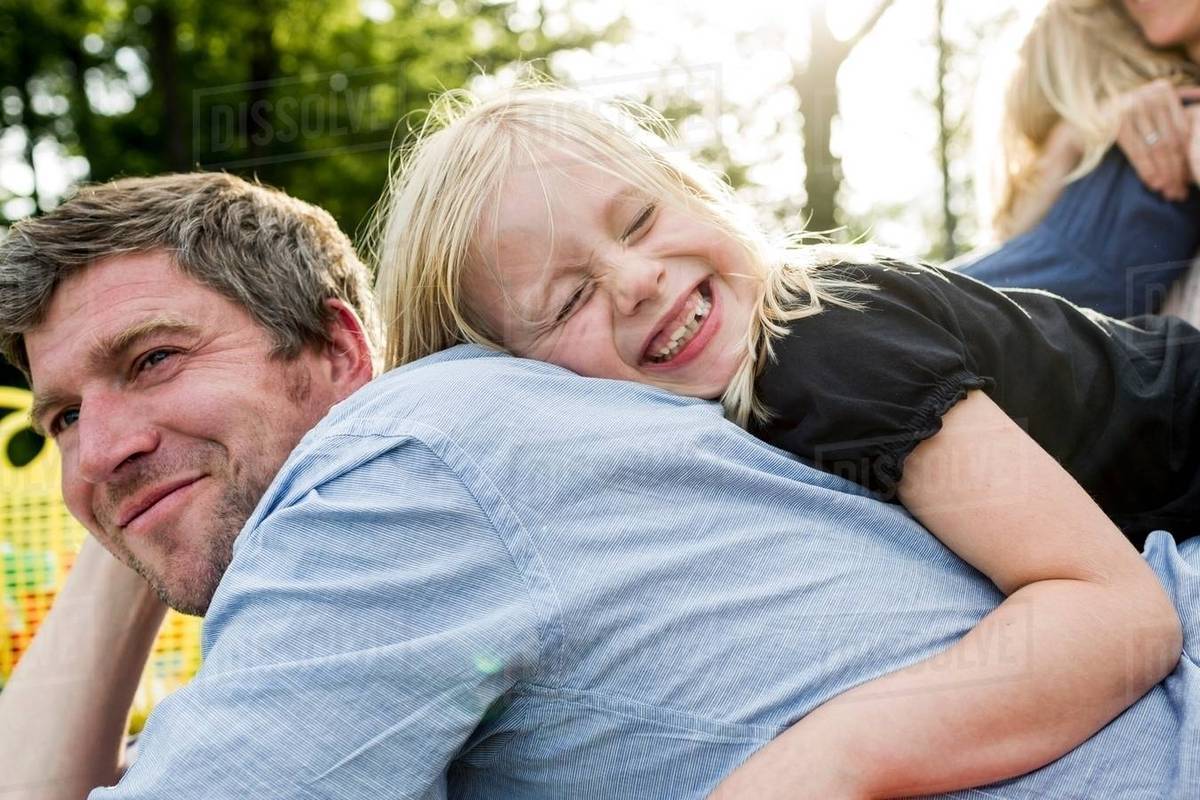Girl hugging father in park - Royalty-free Stock Photo | Dissolve