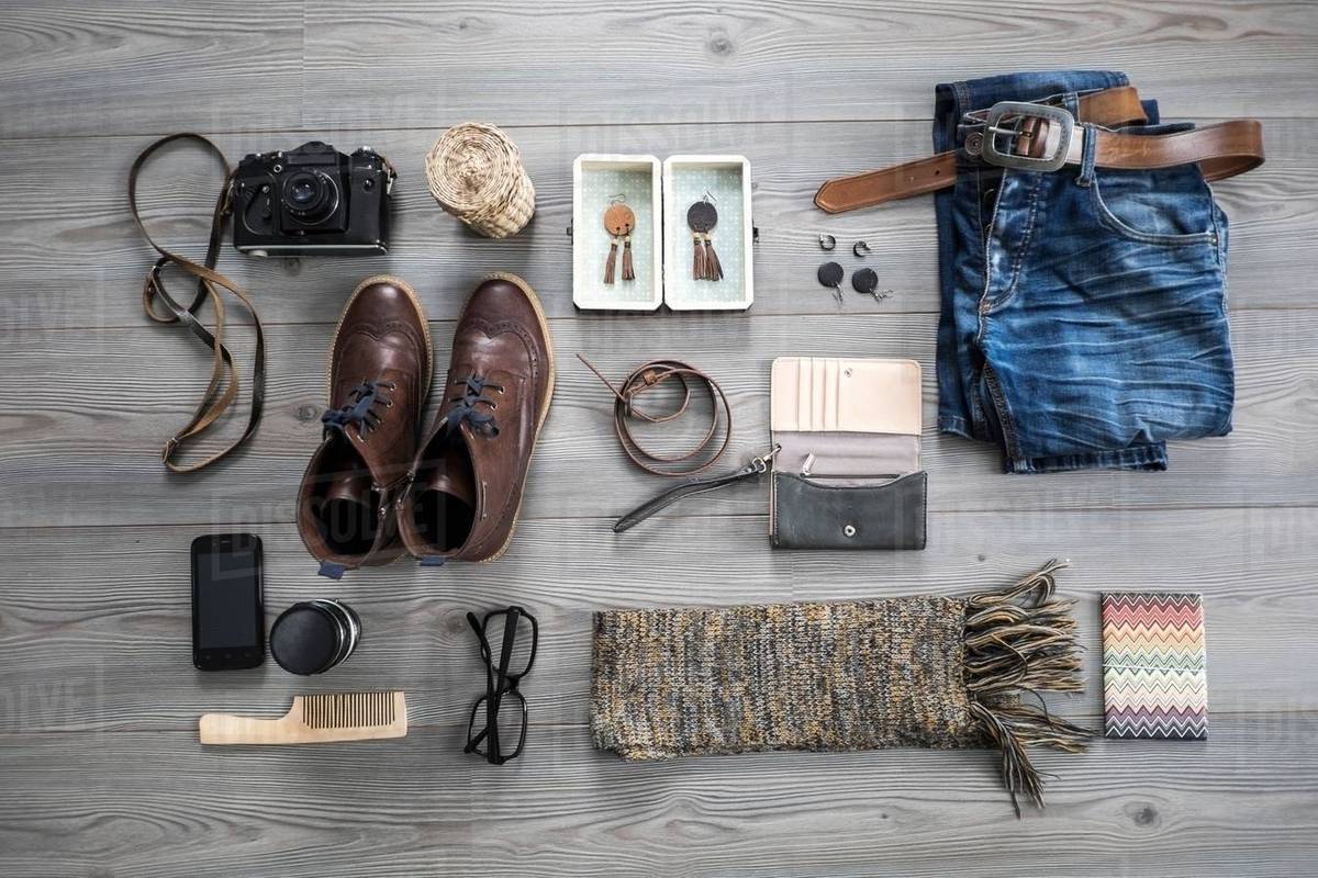 Overhead view of variety of objects including camera, jeans and ...