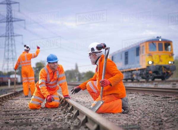 Apprentice railway worker instructed by engineer on railway - Stock ...
