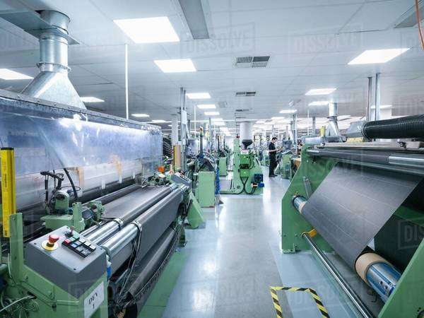 Worker operating carbon fibre loom in carbon fibre factory - Stock ...