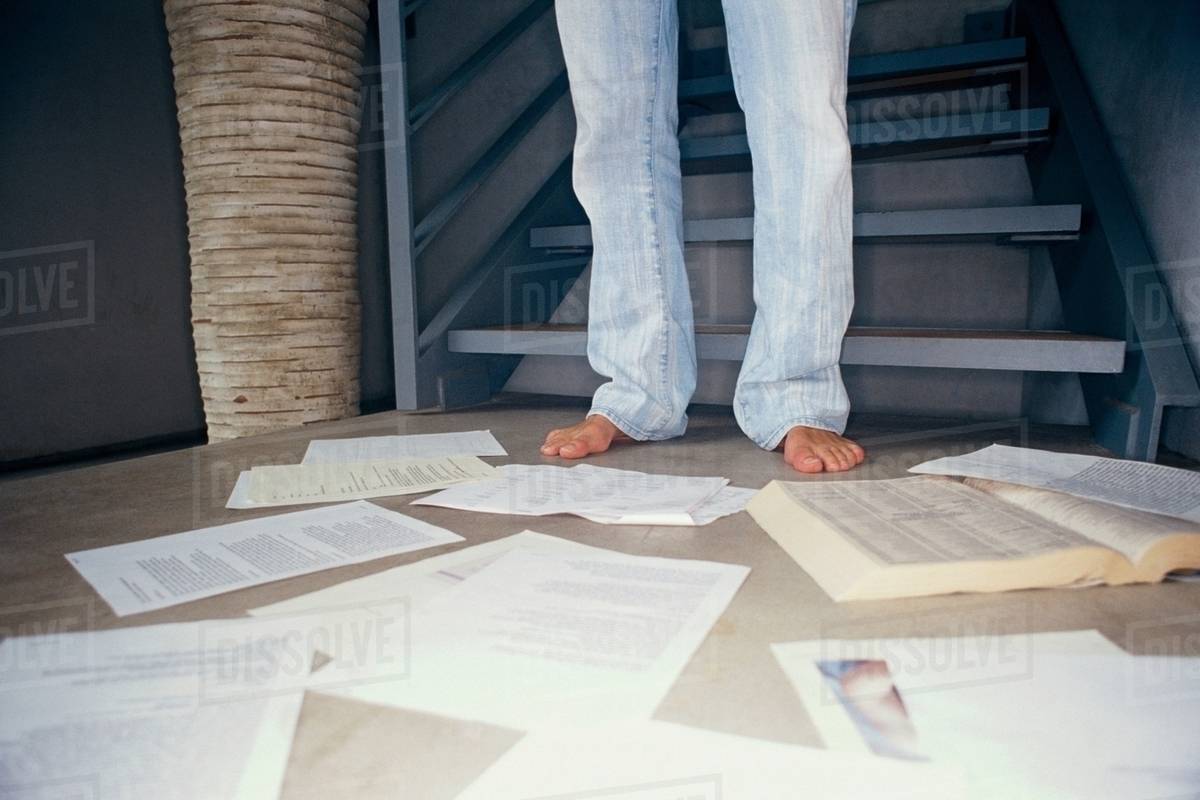 Man surrounded by papers on floor - Stock Photo - Dissolve
