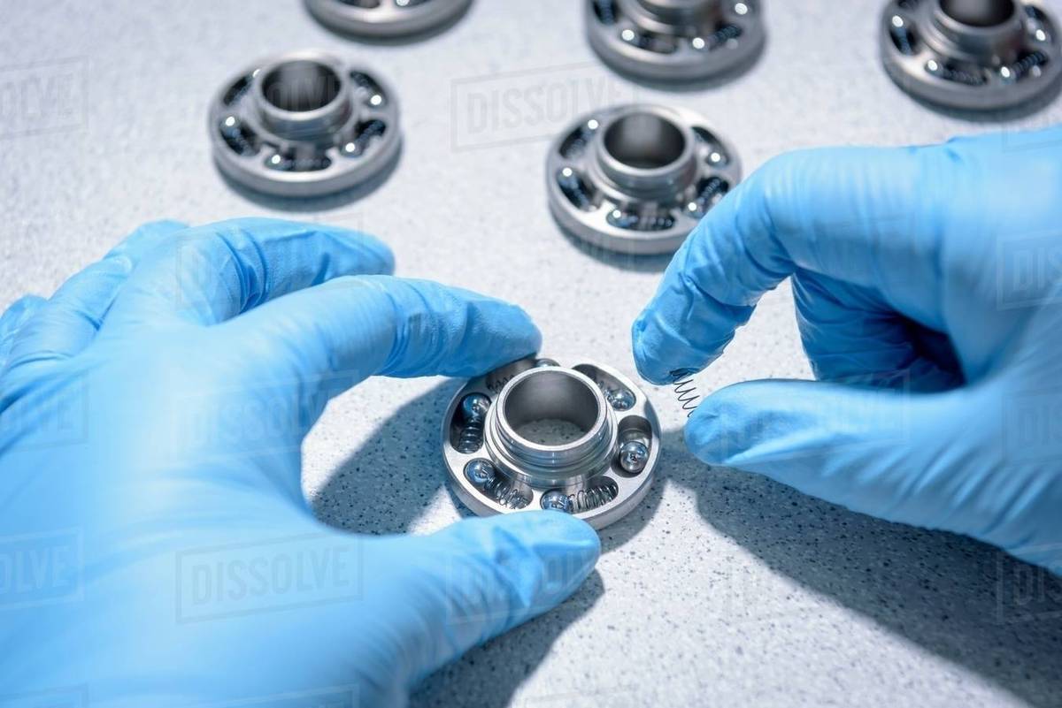 Close up of worker assembling valve rotators on assembly line in ...