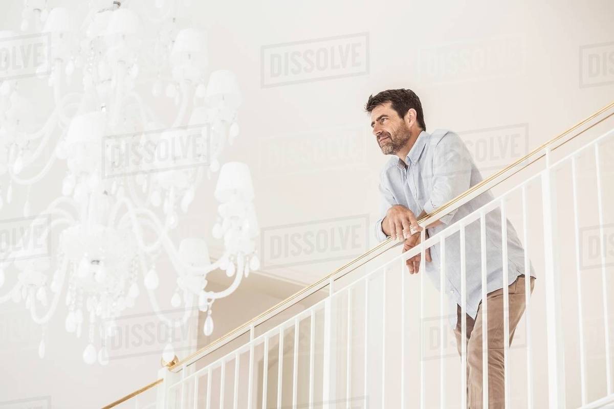 Portrait of mature man, at home, leaning on banister - Stock Photo ...