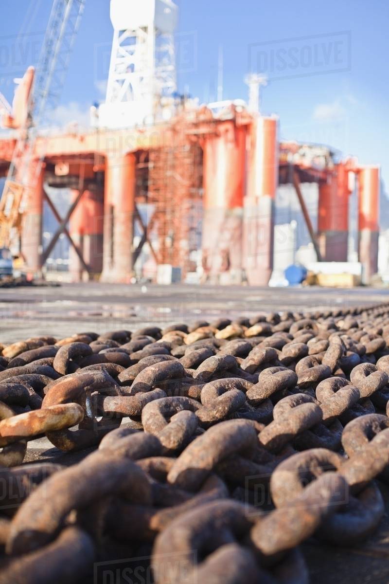 Rusted chains on oil rig - Stock Photo - Dissolve