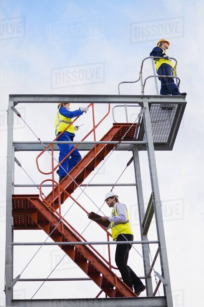 Workers climbing stairs on site - Stock Photo - Dissolve