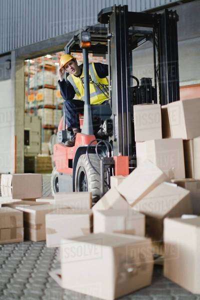 Worker using forklift to pick up boxes - Royalty-free Stock Photo ...
