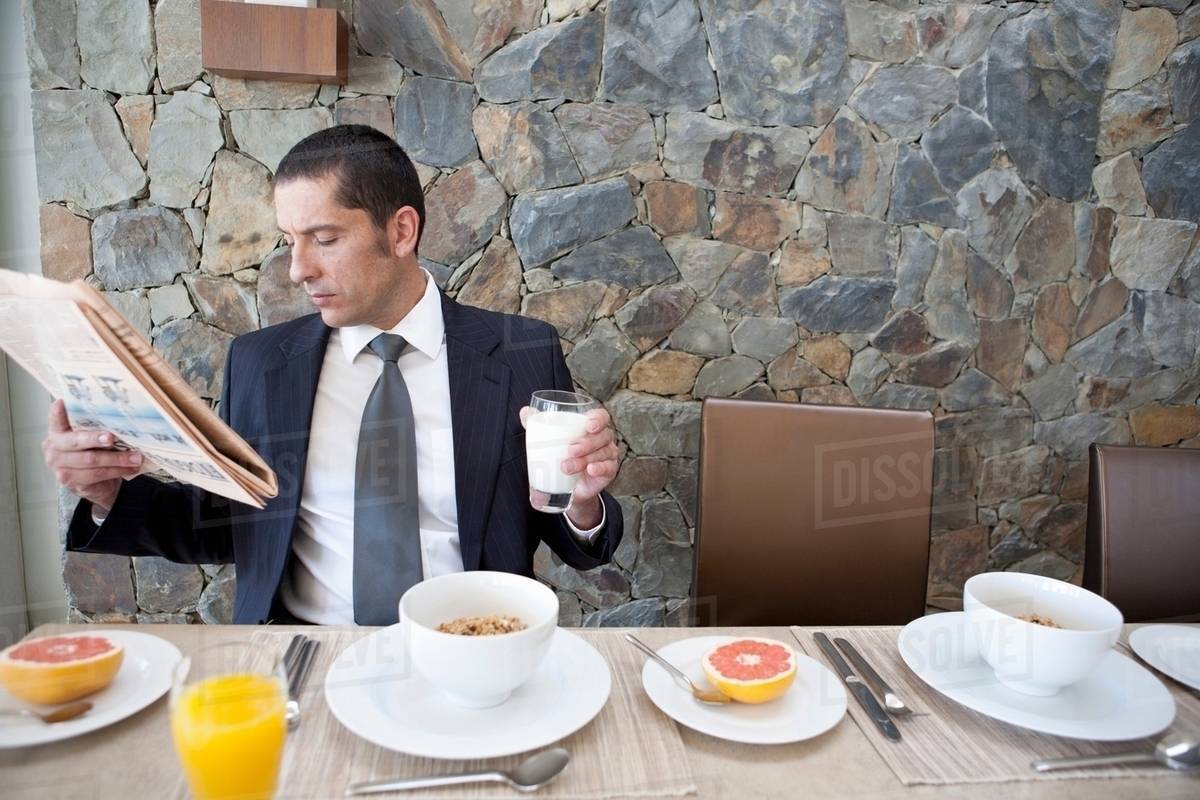 Businessman eating breakfast - Stock Photo - Dissolve