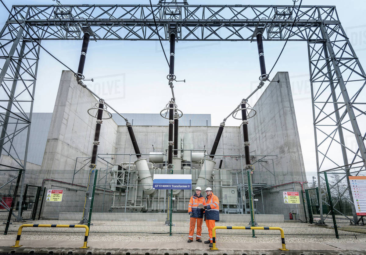 Workers with 400KV transformer in gas-fired power station, low angled ...