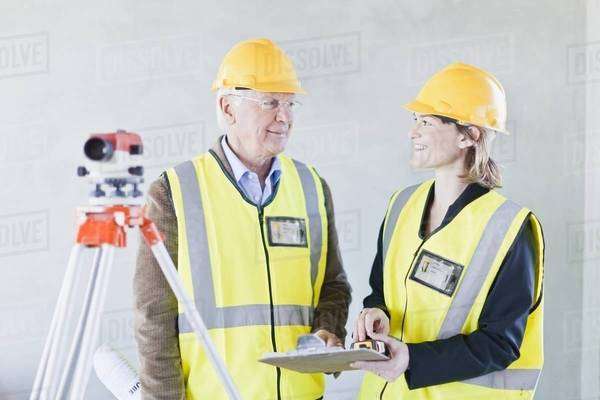 Construction workers talking on site - Royalty-free Stock Photo | Dissolve