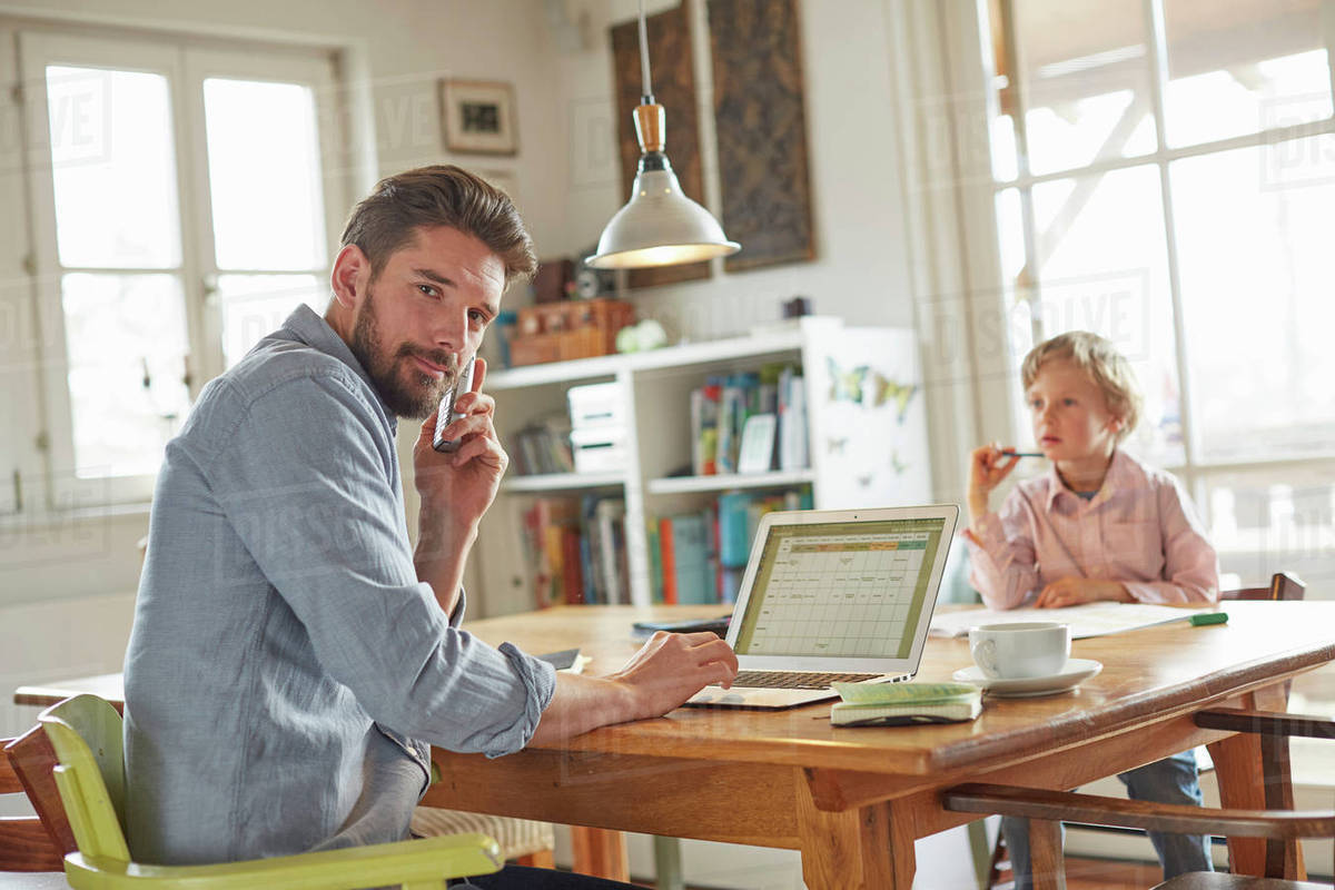 Father on phone while working in home office with son - Royalty-free ...