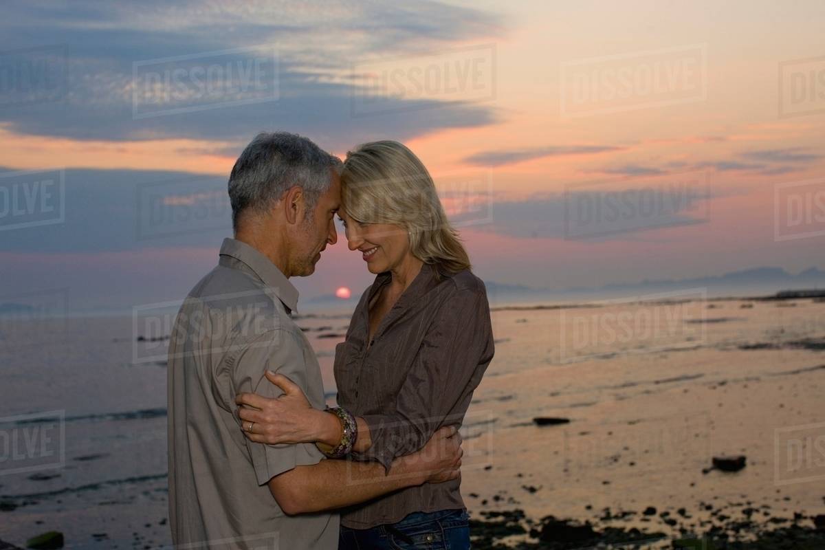Couple hugging at sunset - Royalty-free Stock Photo | Dissolve