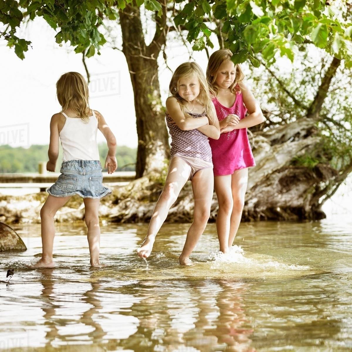 Smiling girls playing in lake - Royalty-free Stock Photo | Dissolve