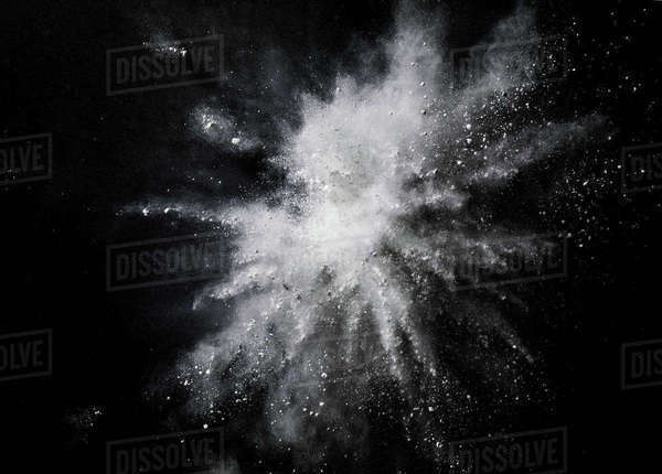 White dust exploding mid air against black background - Stock Photo ...