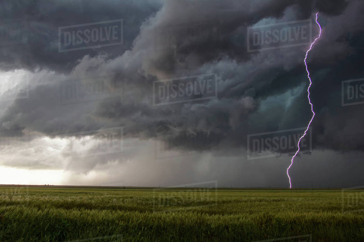 A smooth channel lightning bolt arcs to the ground through the ...