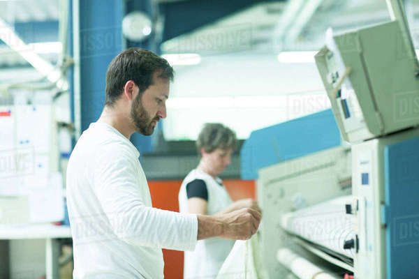 Colleagues working in launderette - Stock Photo - Dissolve