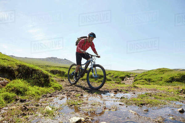 Cyclists cycling through water - Royalty-free Stock Photo | Dissolve