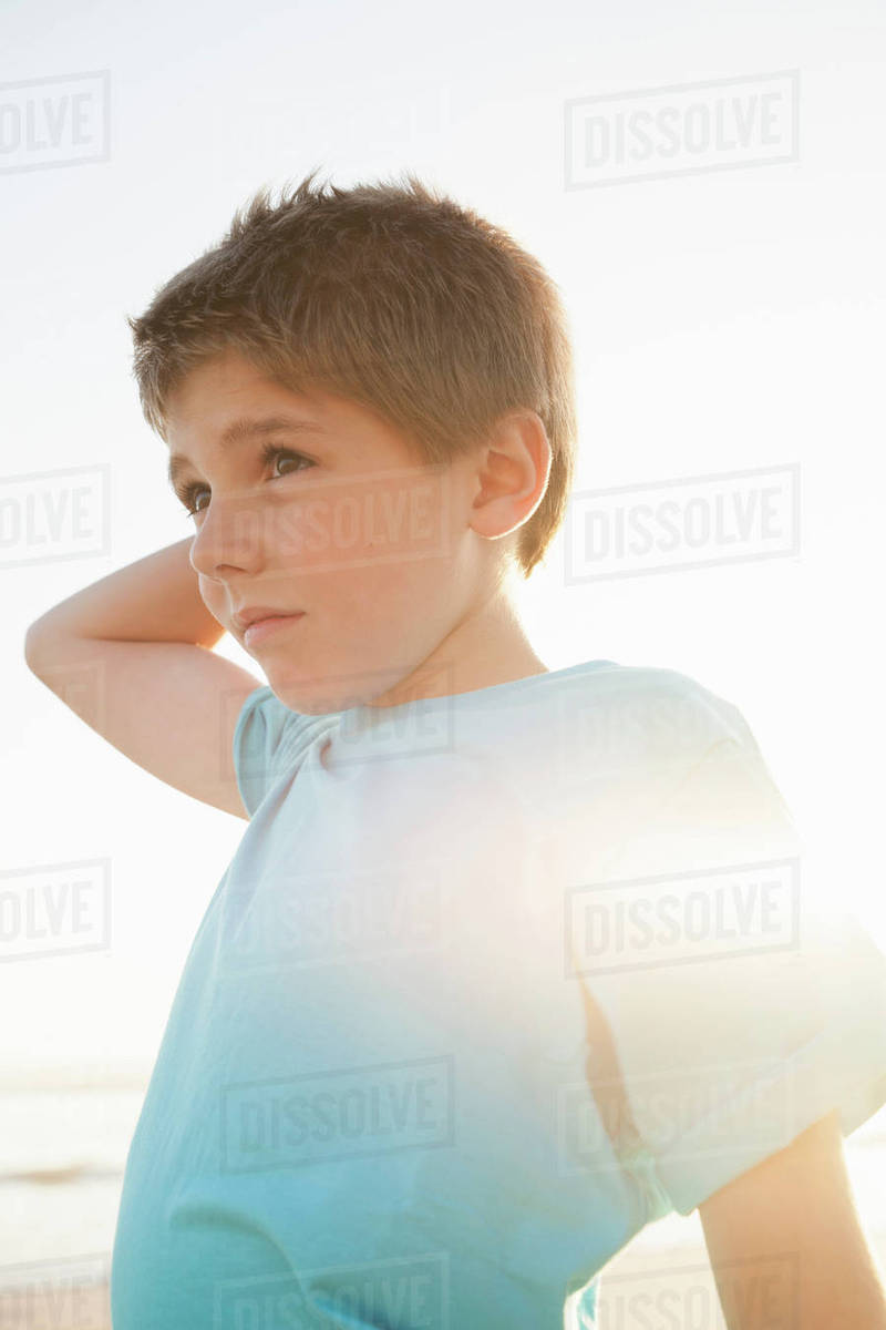 Boy with hand on head looking away - Royalty-free Stock Photo | Dissolve