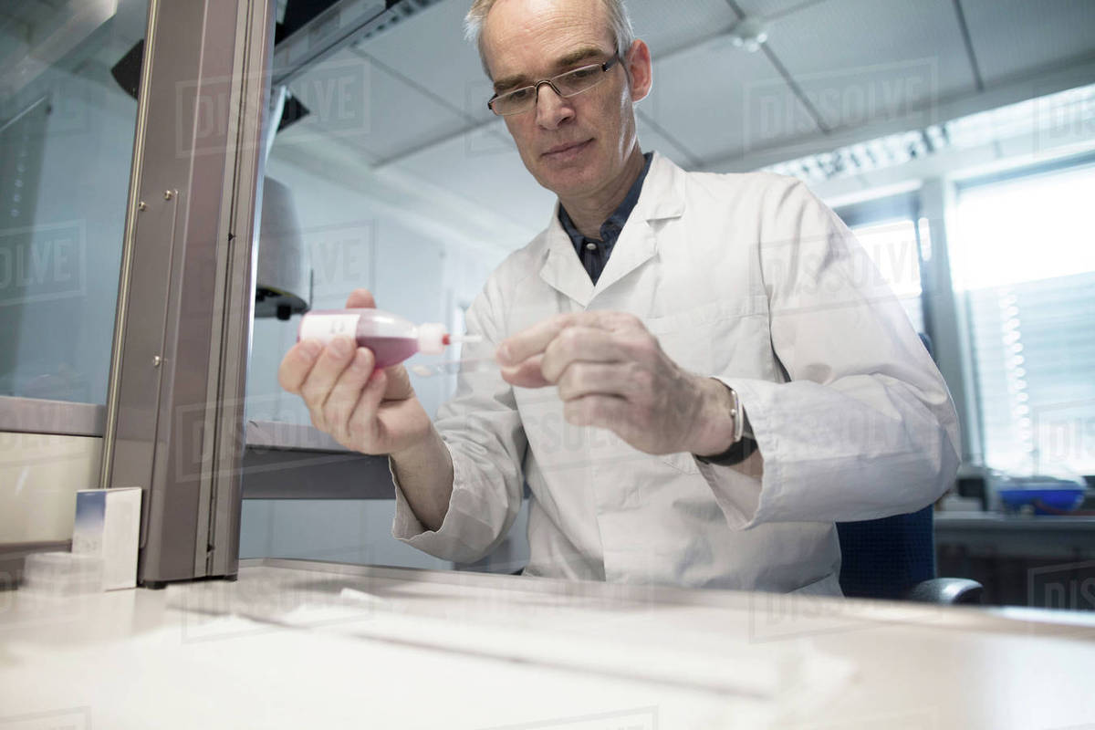 Male meteorologist preparing microscope slide in weather station ...