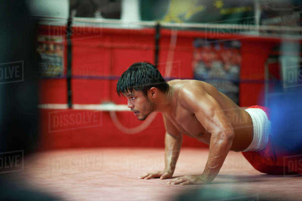 Boxer doing push-ups in boxing ring - Royalty-free Stock Photo | Dissolve