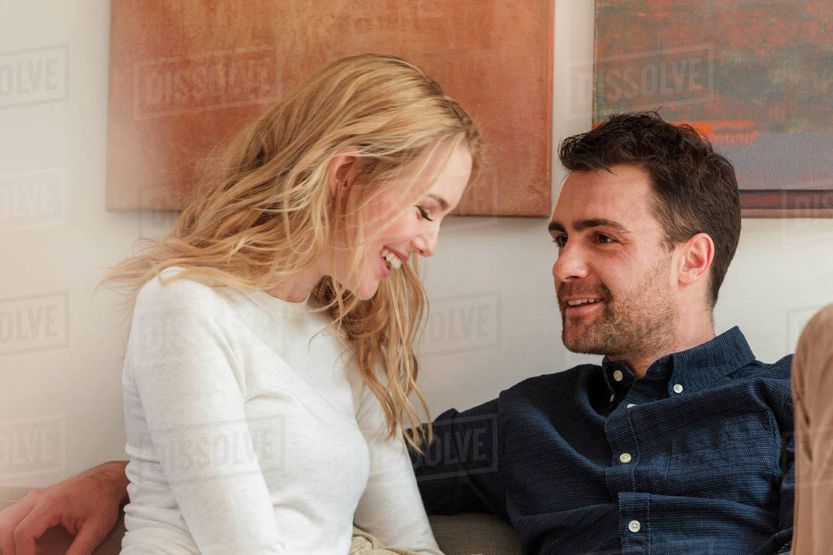 Couple snuggling together smiling - Royalty-free Stock Photo | Dissolve