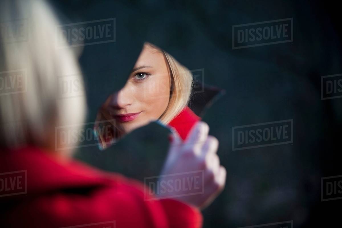 Woman admiring herself in mirror shard - Royalty-free Stock Photo ...