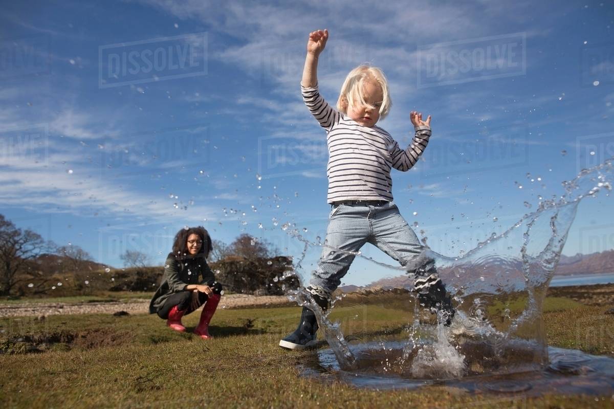 Boy splashing in puddle - Royalty-free Stock Photo | Dissolve