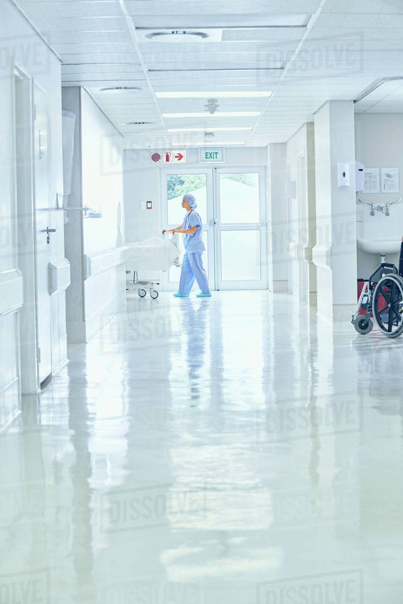 Female nurse pushing bed on hospital corridor - Royalty-free Stock ...