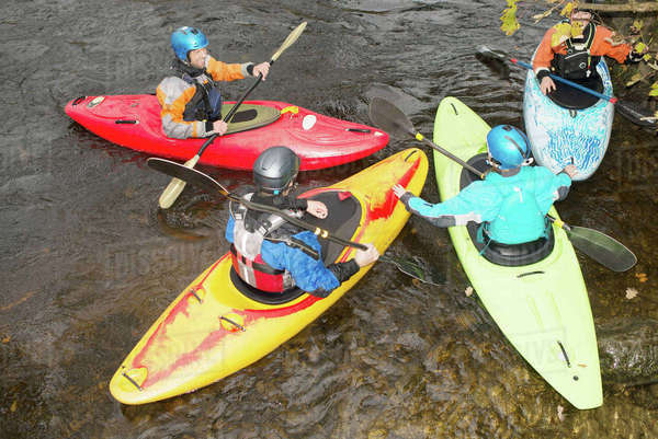 Overhead view of kayak team talking on river Dee - Stock Photo - Dissolve