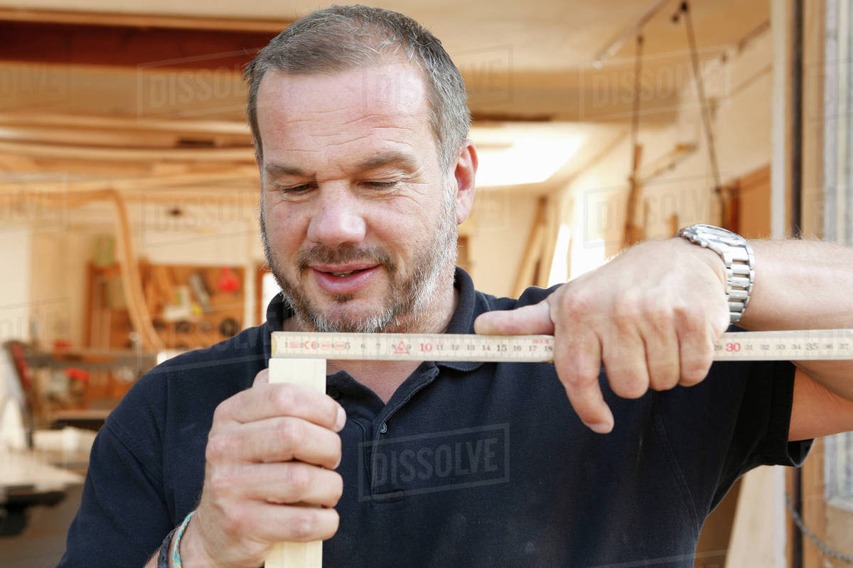 Man measuring timber - Royalty-free Stock Photo | Dissolve